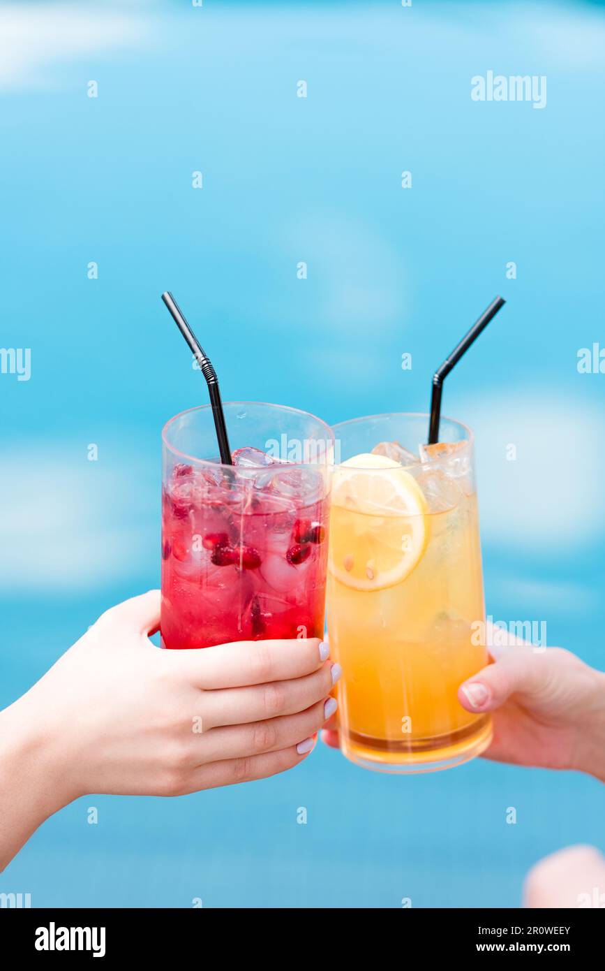 Two people clinking cocktail glasses hi-res stock photography and ...