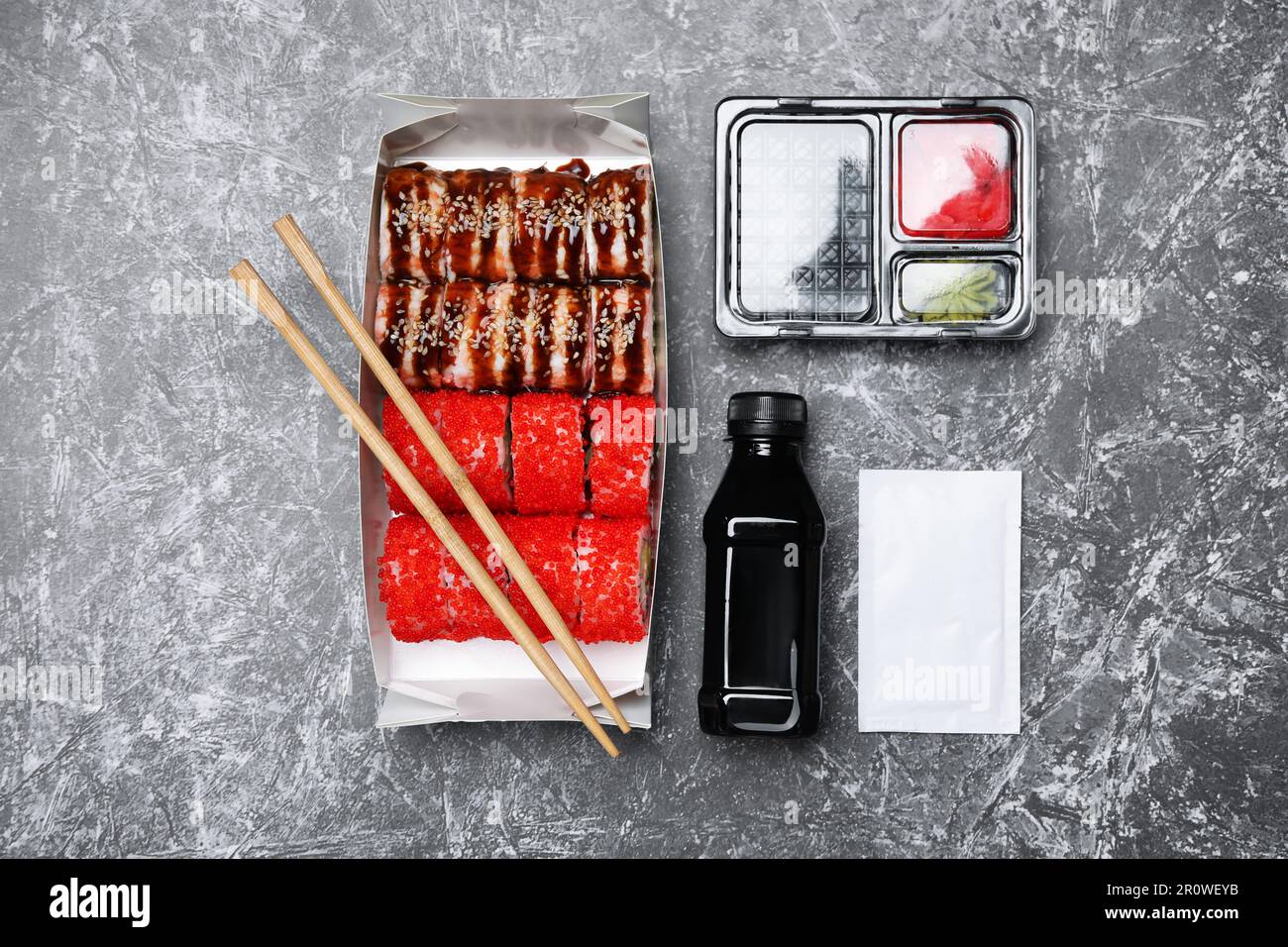 Delicious sushi rolls served on grey textured table, flat lay. Food ...