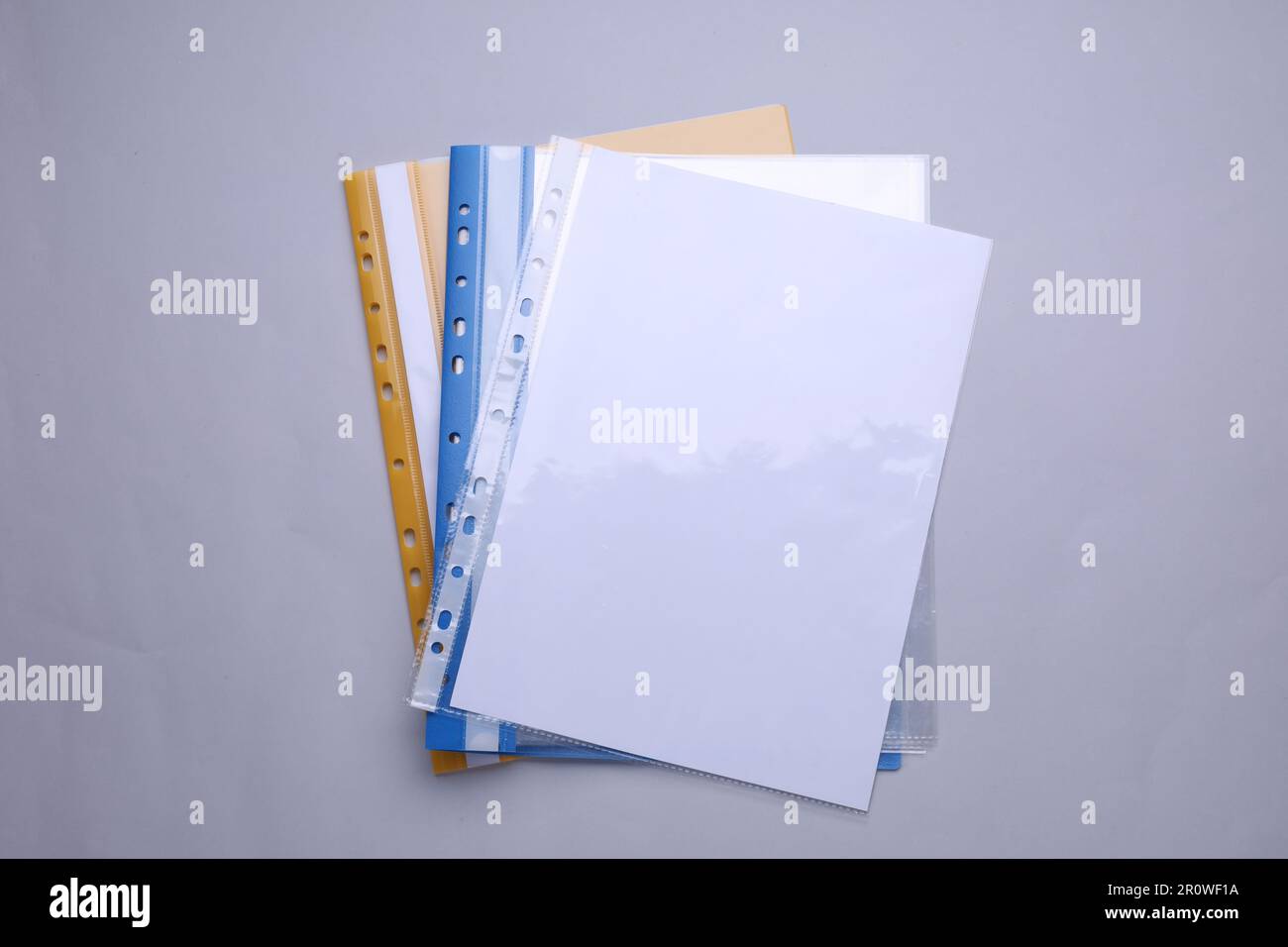 File folders with punched pockets and paper sheets on light grey ...