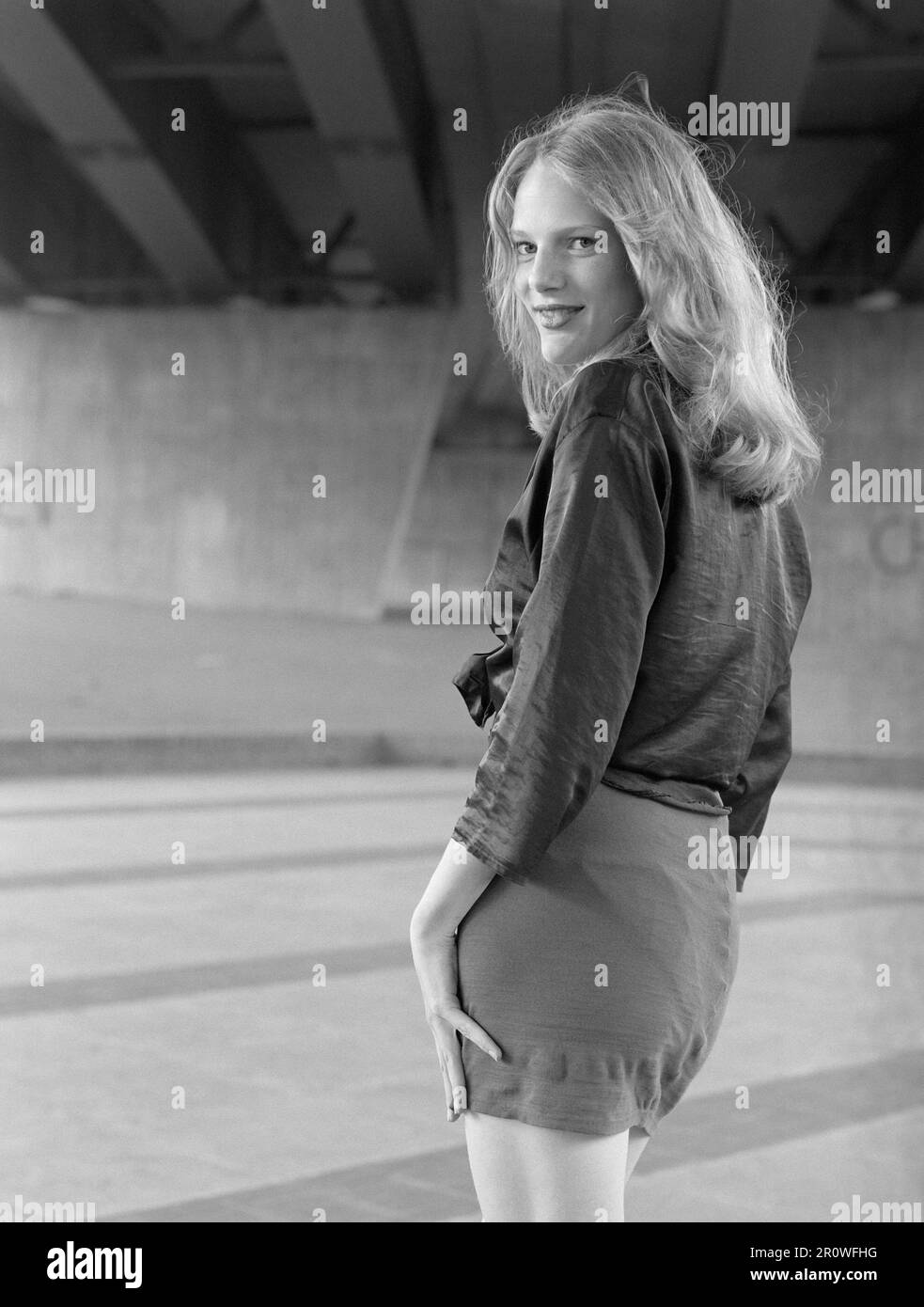 young slim pretty natural blonde female poses for portrait below an ...