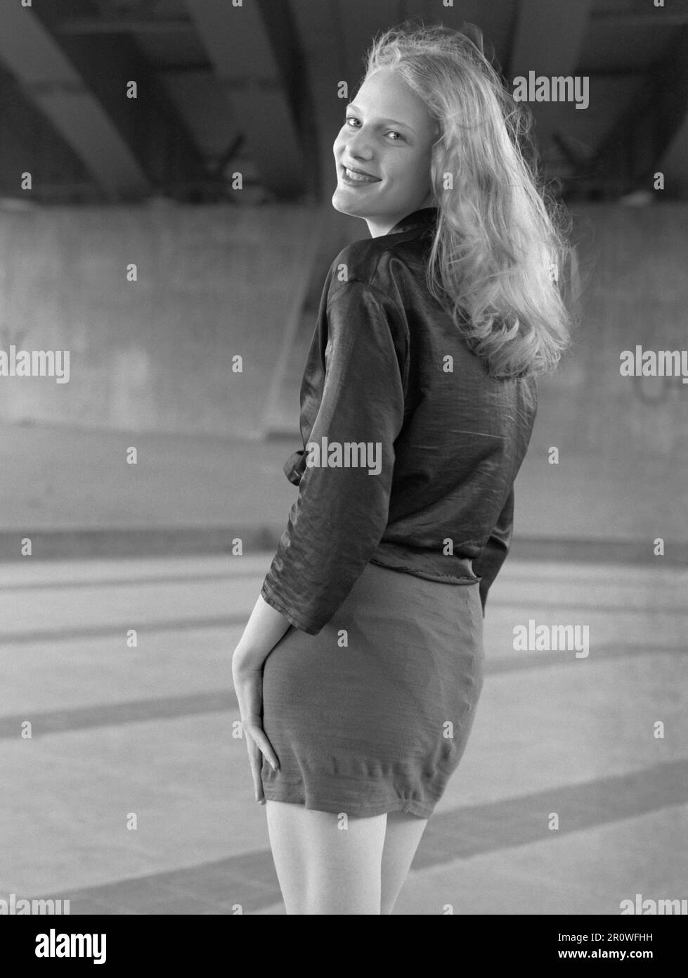 young slim pretty natural blonde female poses for portrait below an ...