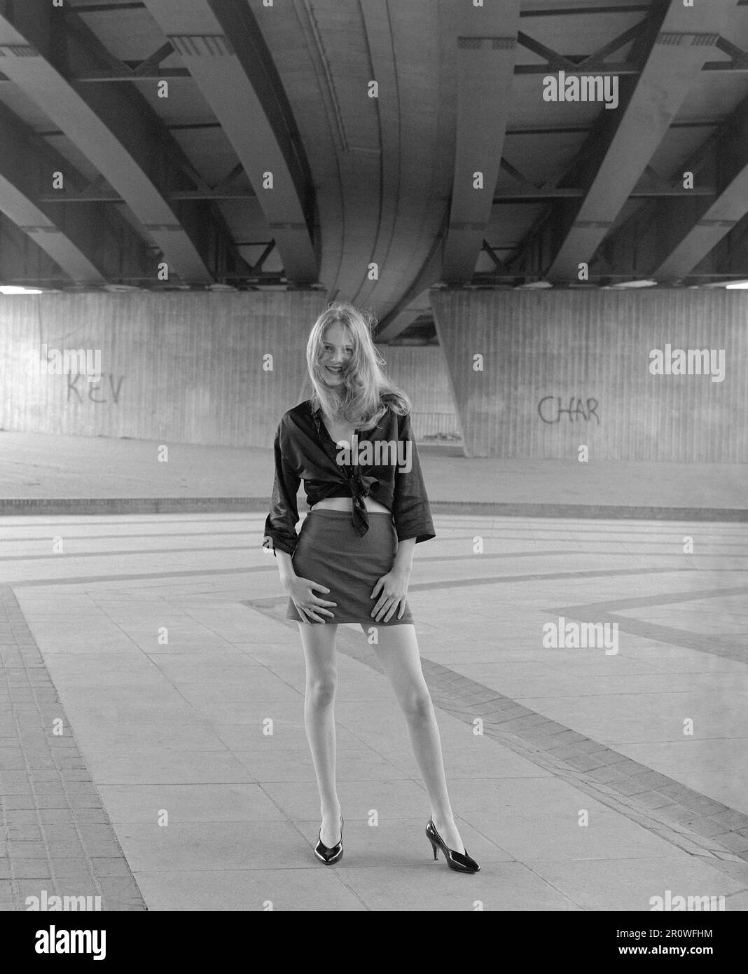 young slim pretty natural blonde female poses for portrait below an ...