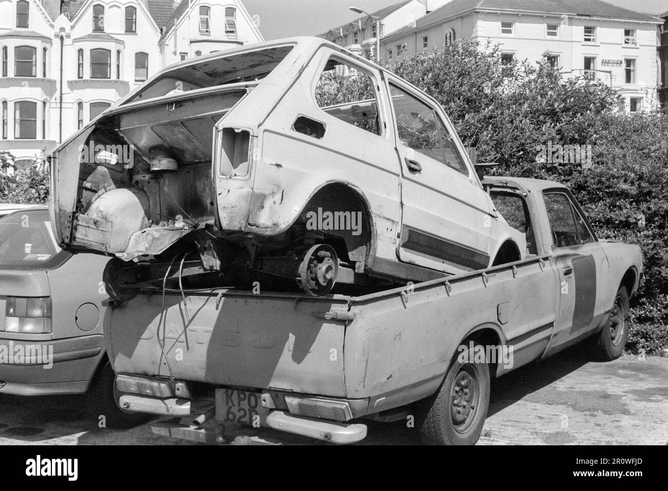 body shell of a scrapped car on the back of an old pick up truck in ...
