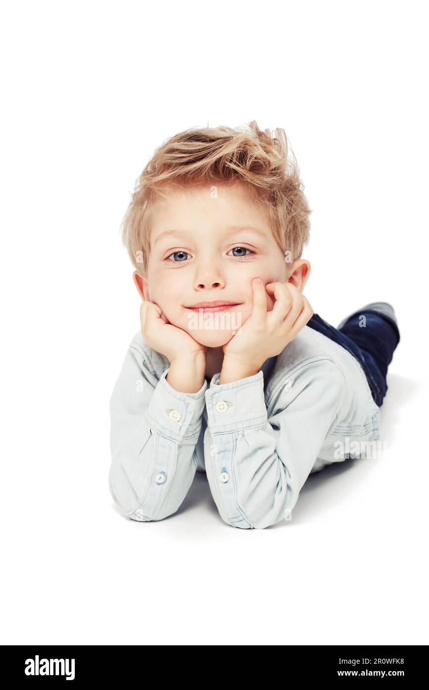 Portrait, smile and boy lying down, relax and cheerful kid isolated ...