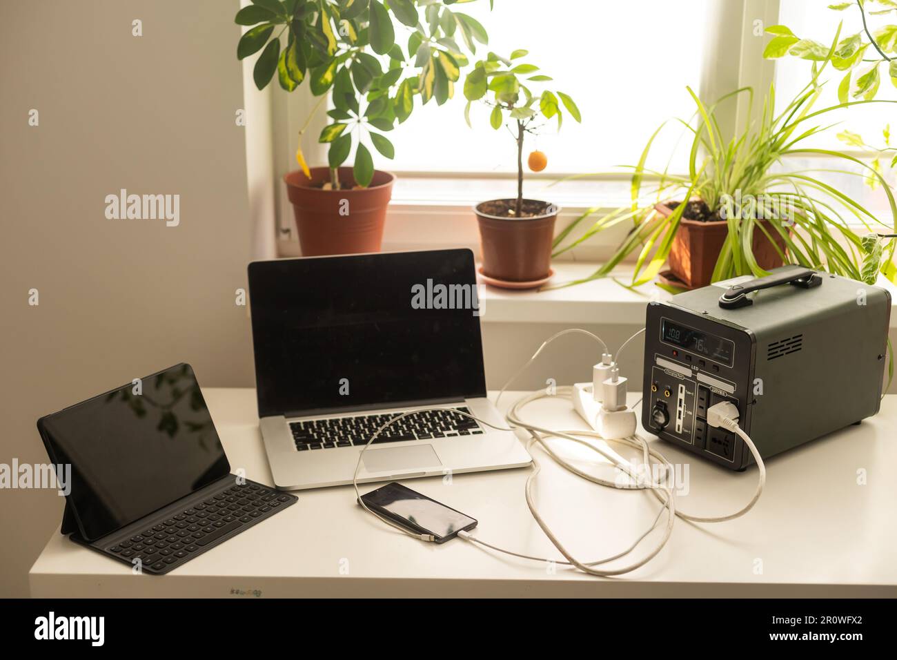 Portable power station charging tablet computer on table in living room ...