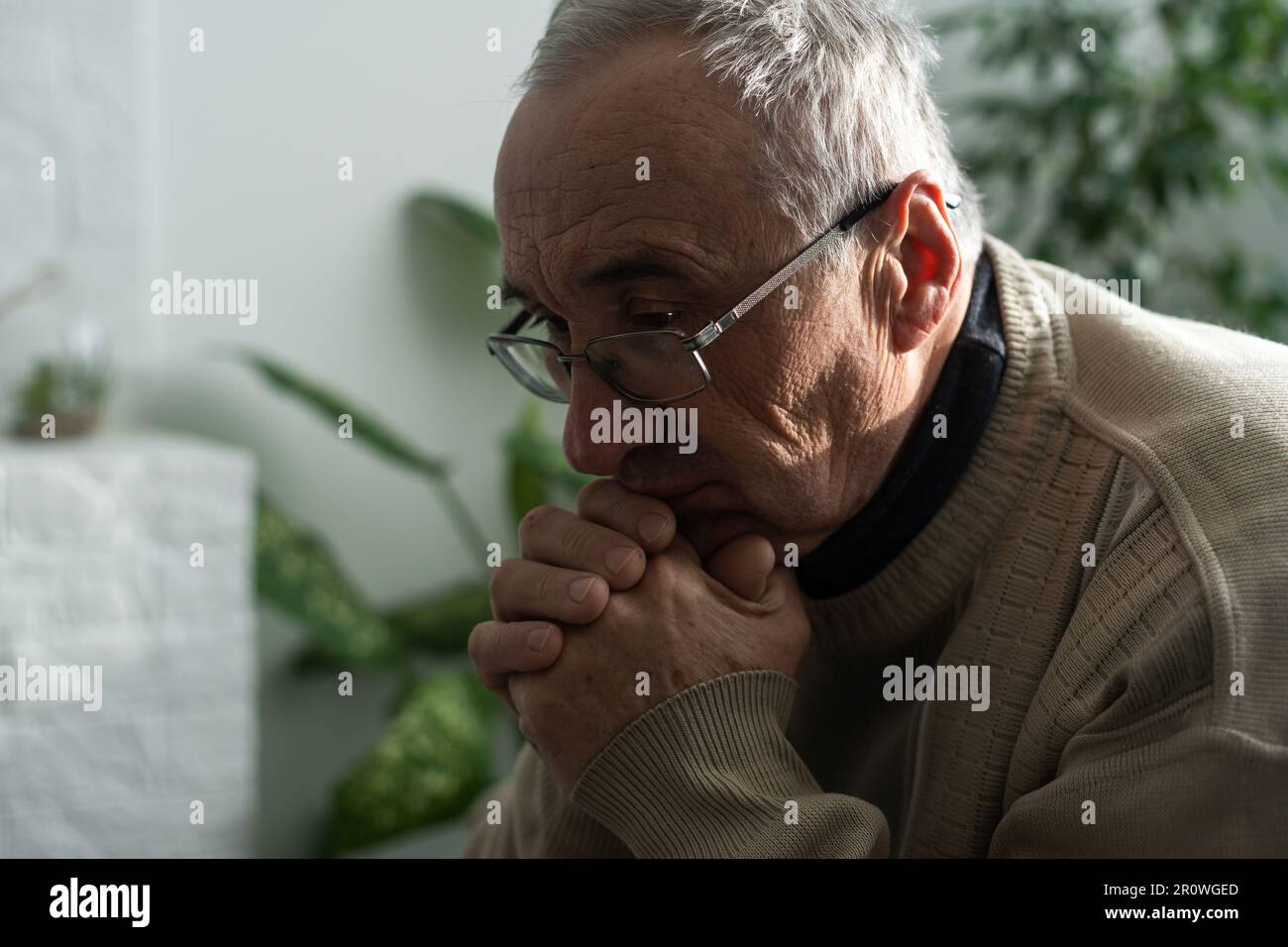 Please, Lord. Nervous worried aged Caucasian man praying on couch at ...