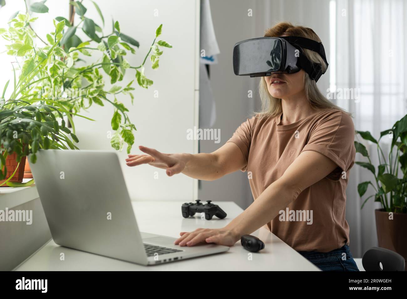 Woman in VR headset looking up at the objects in virtual reality. VR is ...