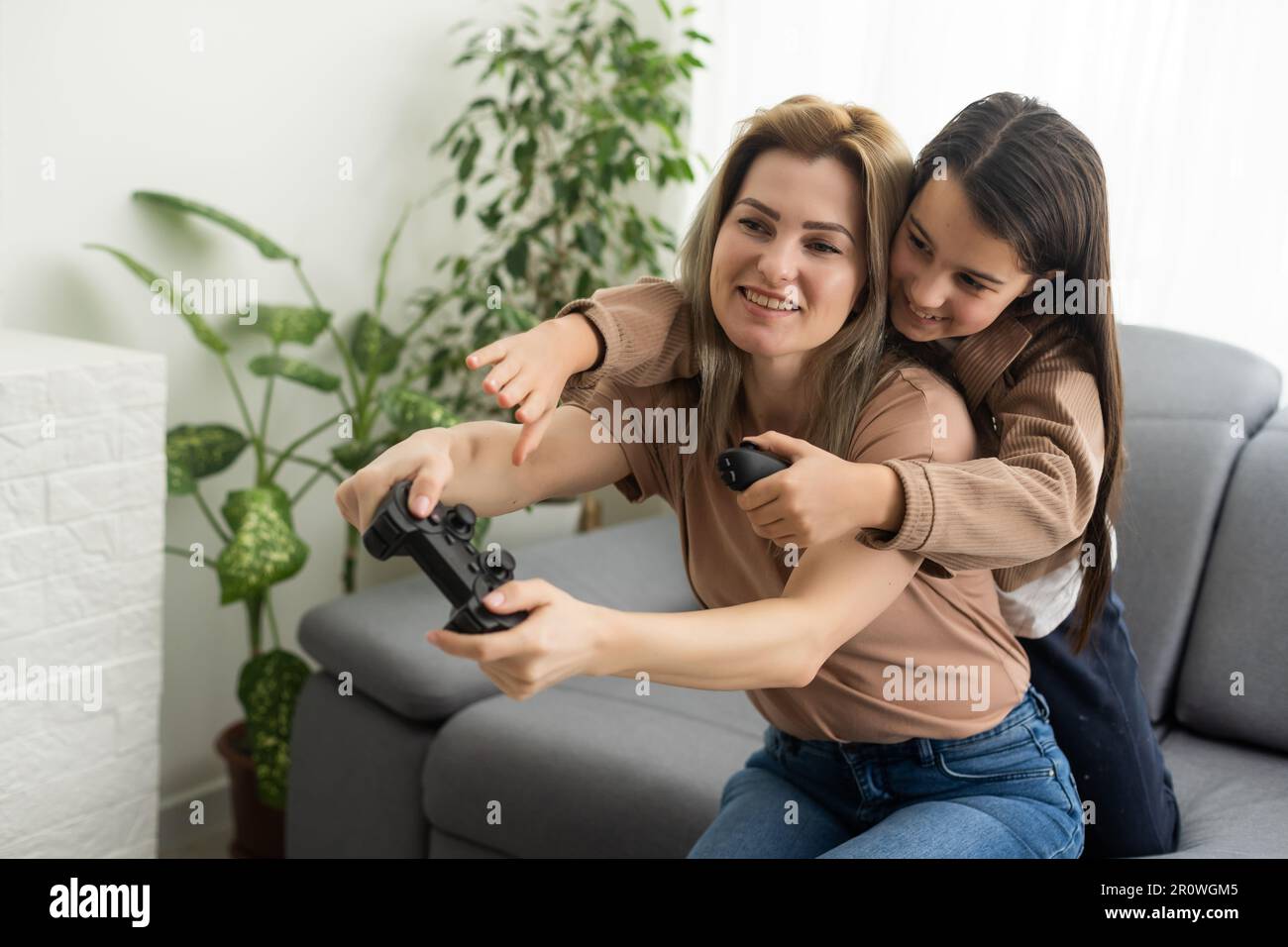 Happy family together. Mother and her child girl playing video games ...