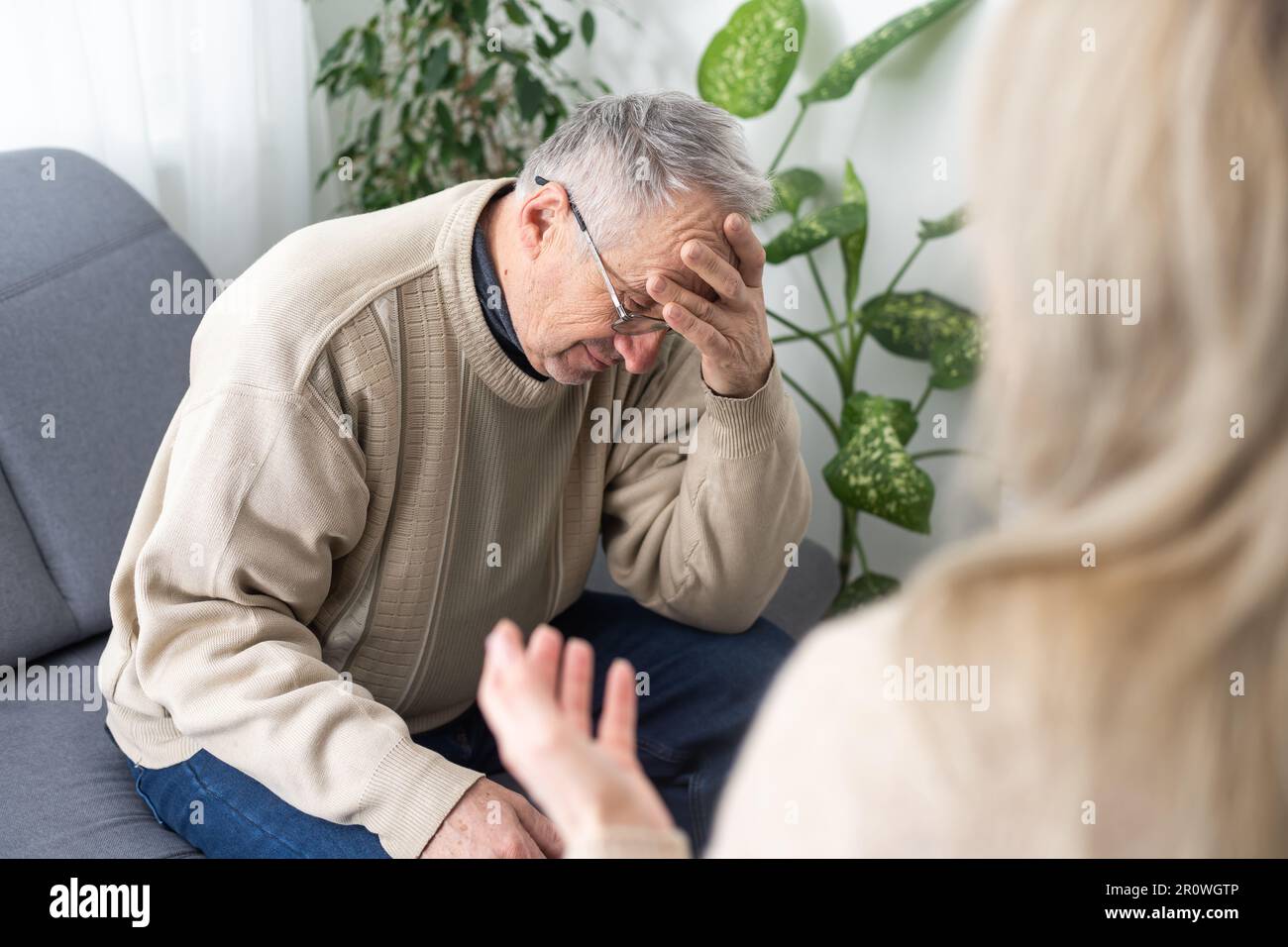 Close up anxious serious old man listening to female doctor at meeting ...