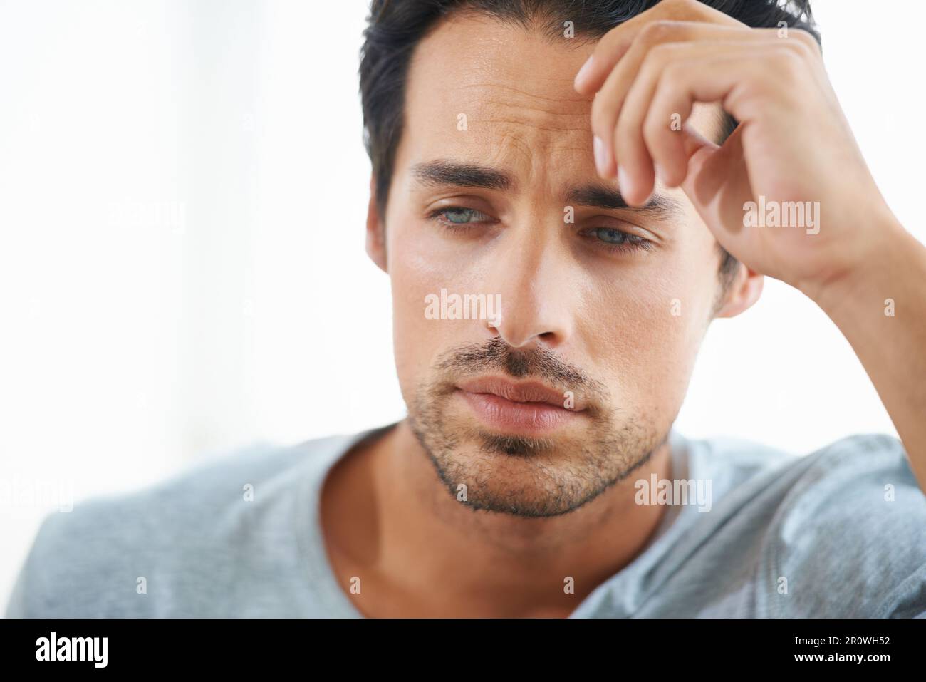 Sad, stress or worried young man on white background in studio with ...