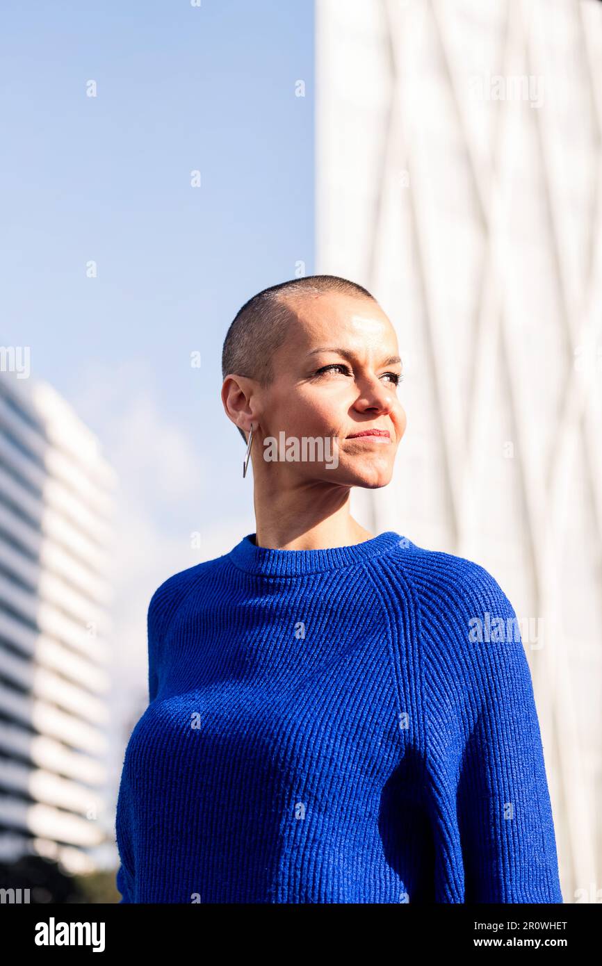 empowered woman with shaved head in cityscape Stock Photo - Alamy