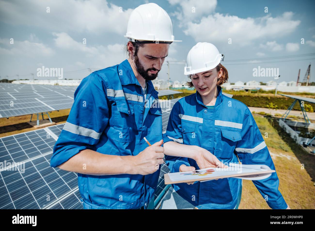 Solar engineers visually examine panel arrays on farm sites using ...