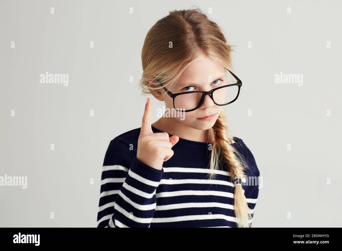 Strict, serious and portrait of a child with a gesture isolated on a ...