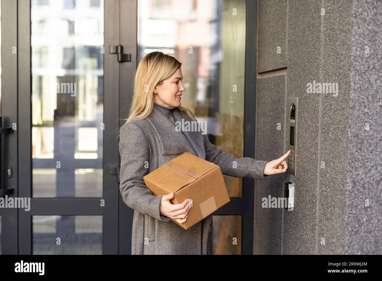 woman using intercom at building entrance Stock Photo - Alamy