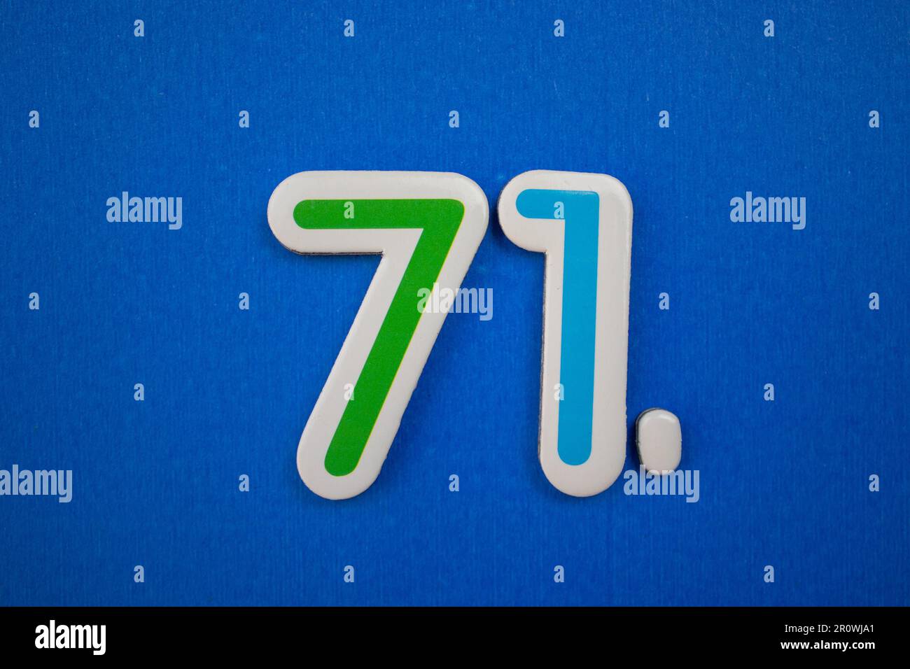 The number 71, placed on a blue background, photographed from above, colored green and light ...