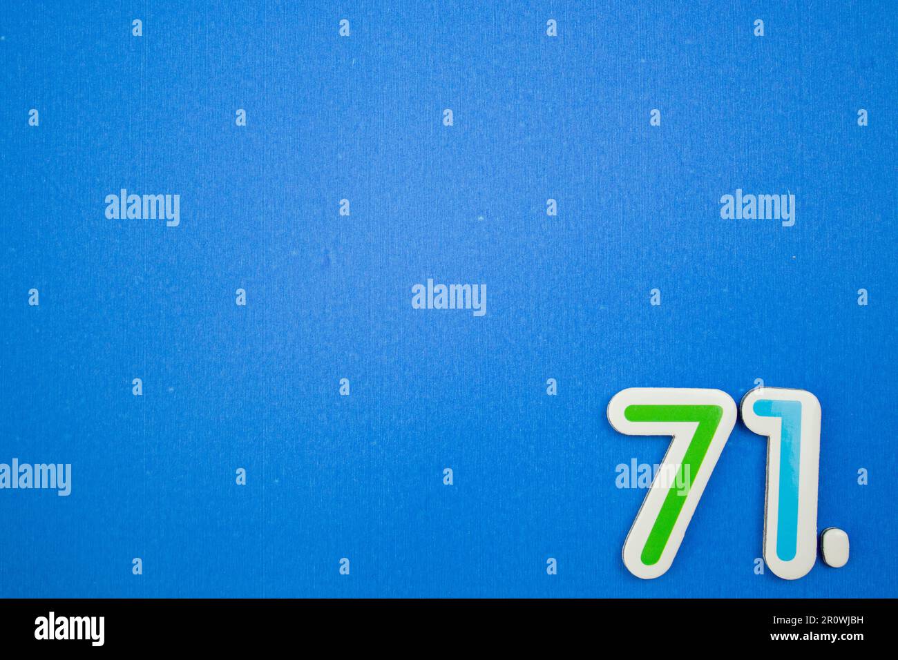 The number 71, placed on the edge of a blue background, photographed ...