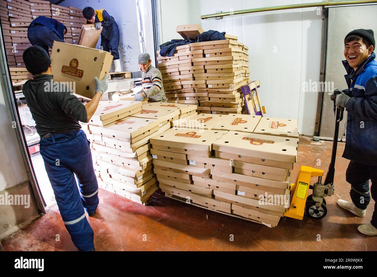 Shymkent, Kazakhstan - April 26, 2012: Young Asian workers loading pack ...