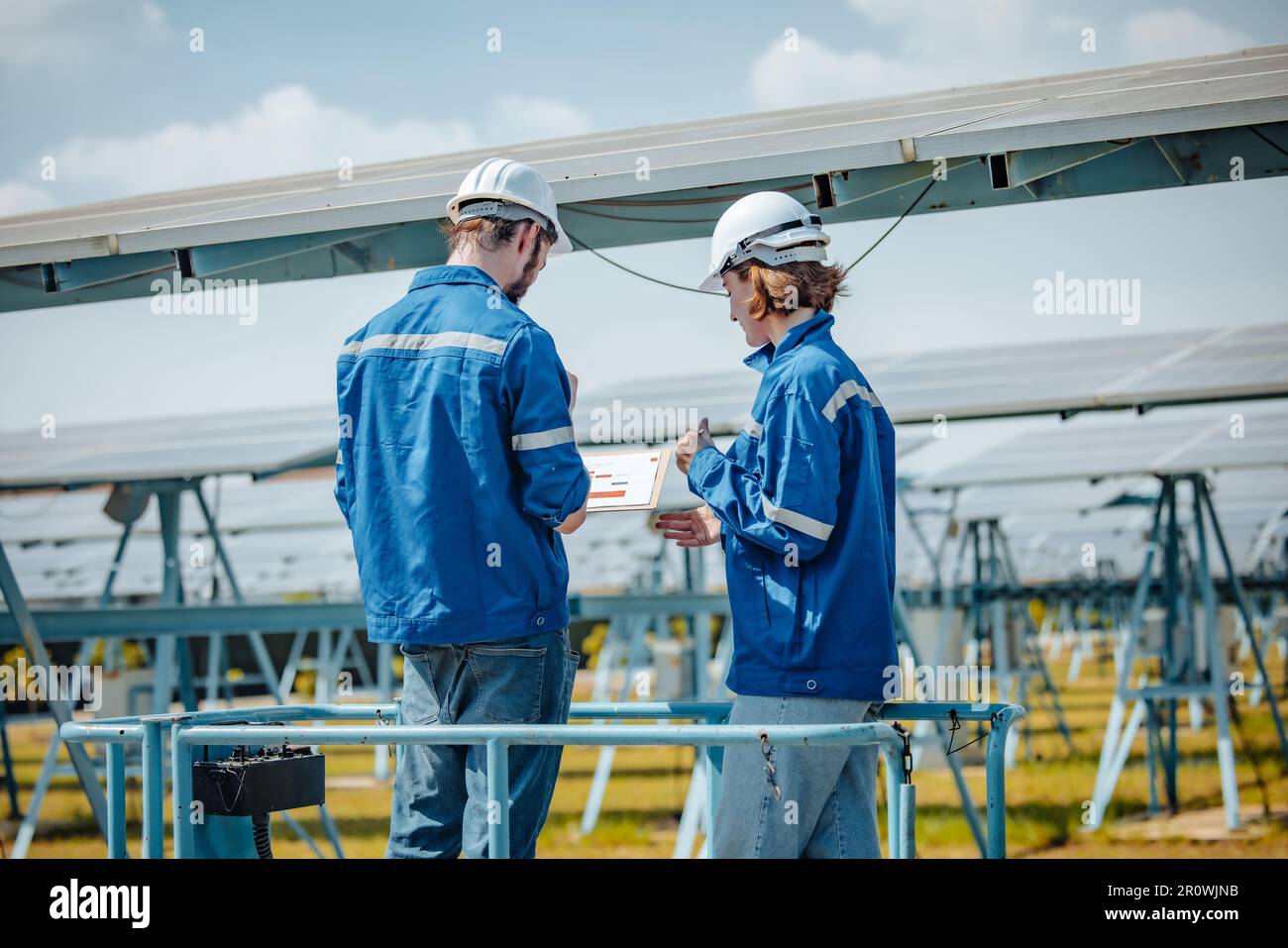 Solar engineers visually examine panel arrays on farm sites using ...