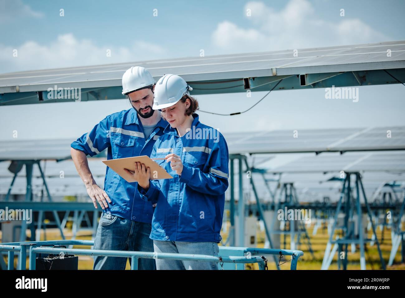 Solar engineers visually examine panel arrays on farm sites using ...