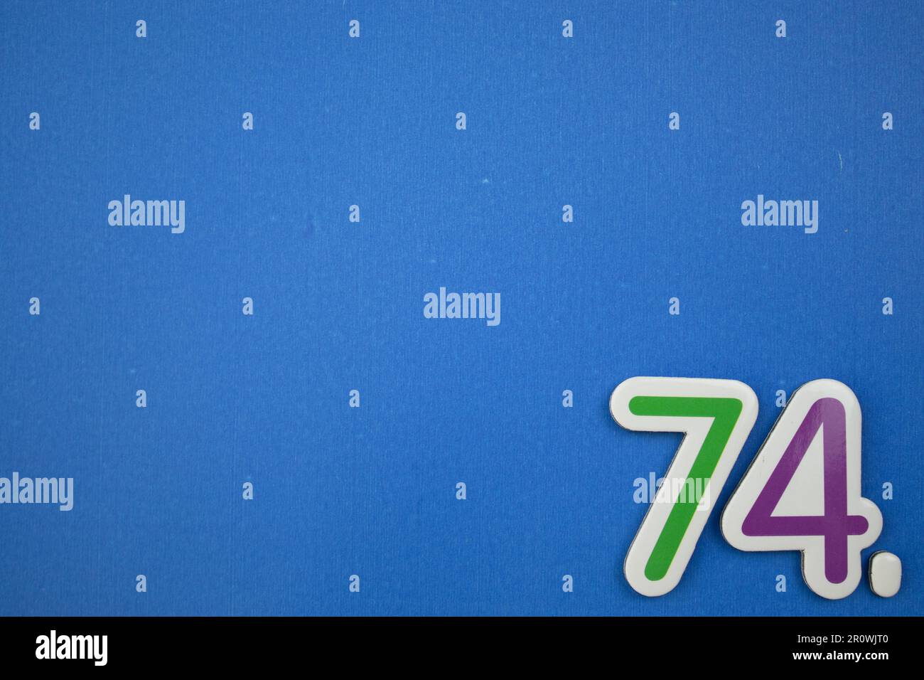 The number 74, green and purple, photographed from above, placed on the ...