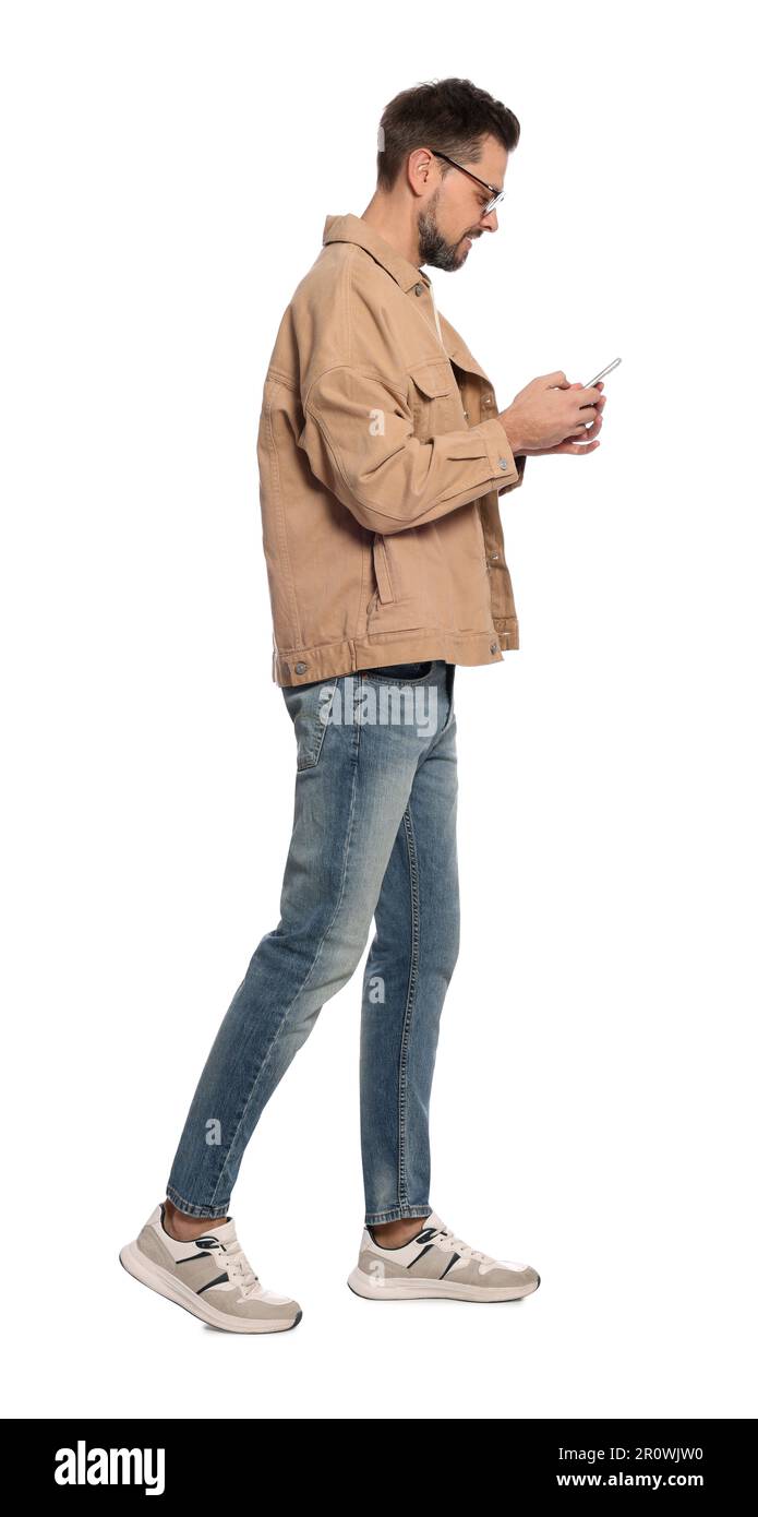 Man using smartphone while walking on white background Stock Photo - Alamy