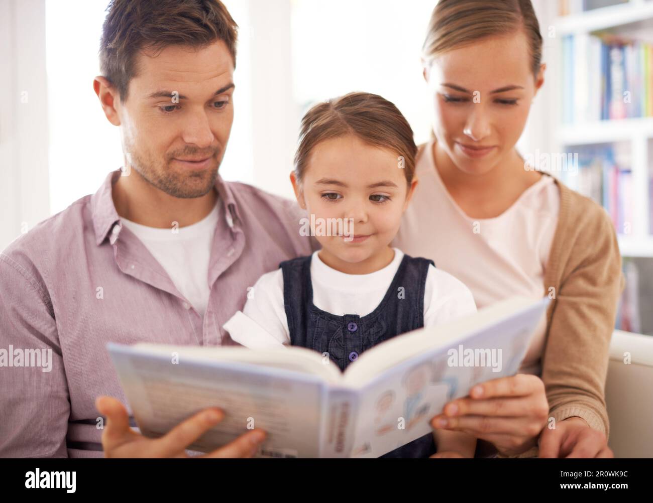 Stories that everyone can enjoy. young parents reading a book with ...