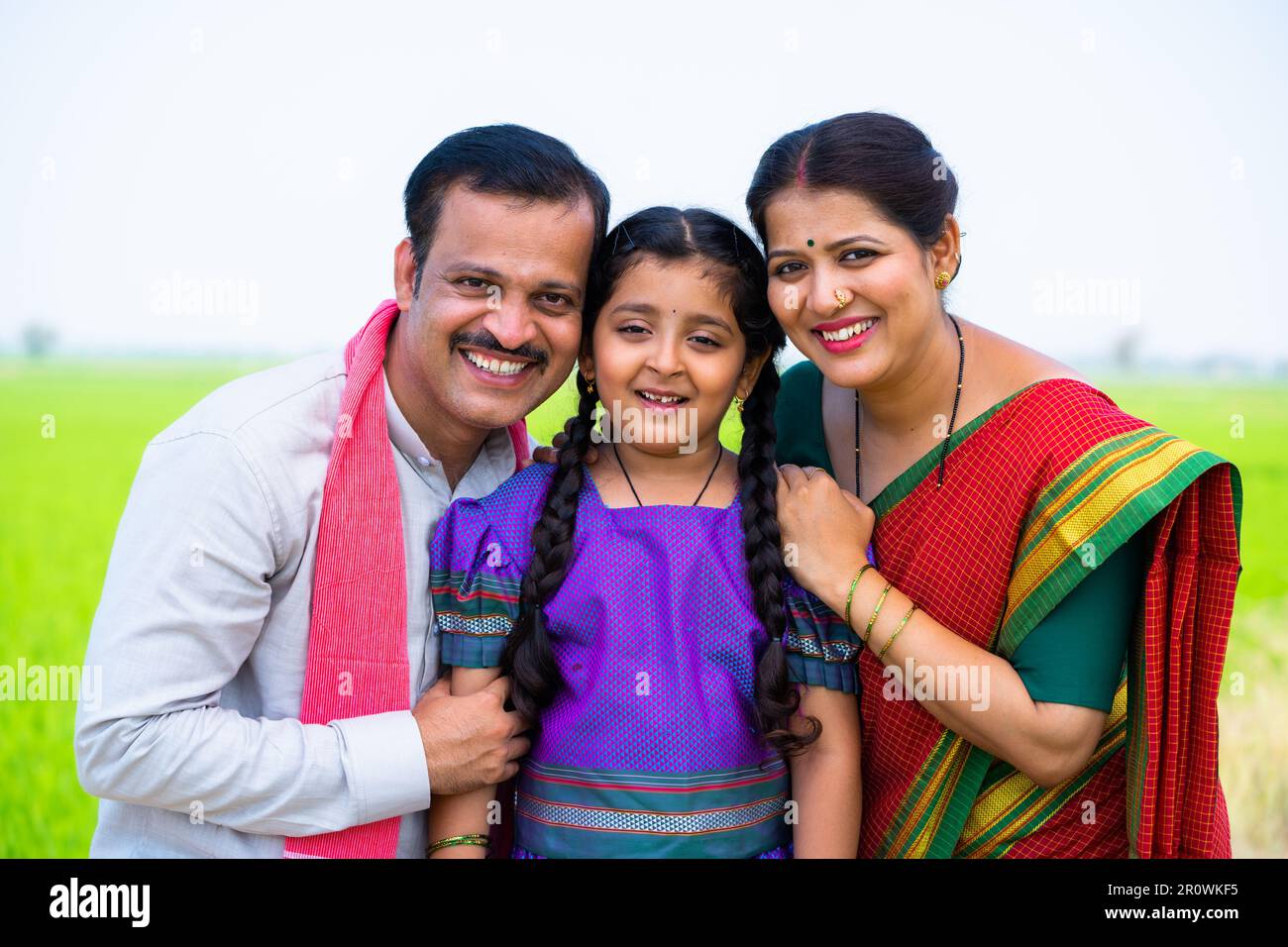 Happy smiling Indian village farming couple with kid looking camera at ...