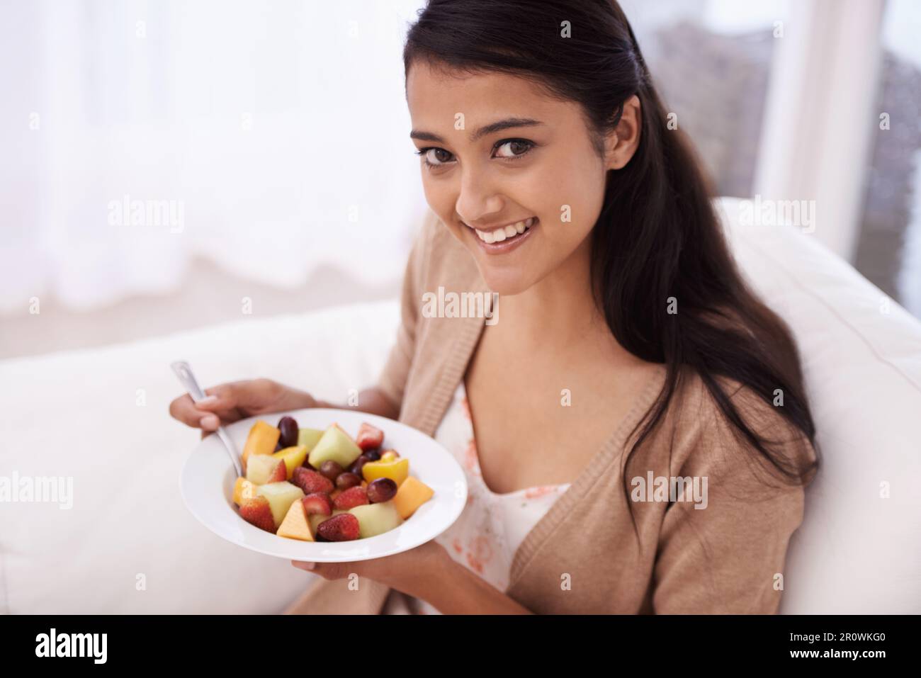 Packed with vitamins. A beautiful young woman enjoying a healthy snack ...