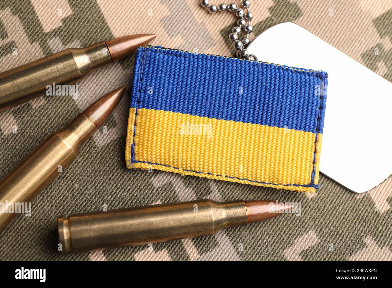 Ukrainian army patch, bullets and ID tags on pixel military camouflage ...
