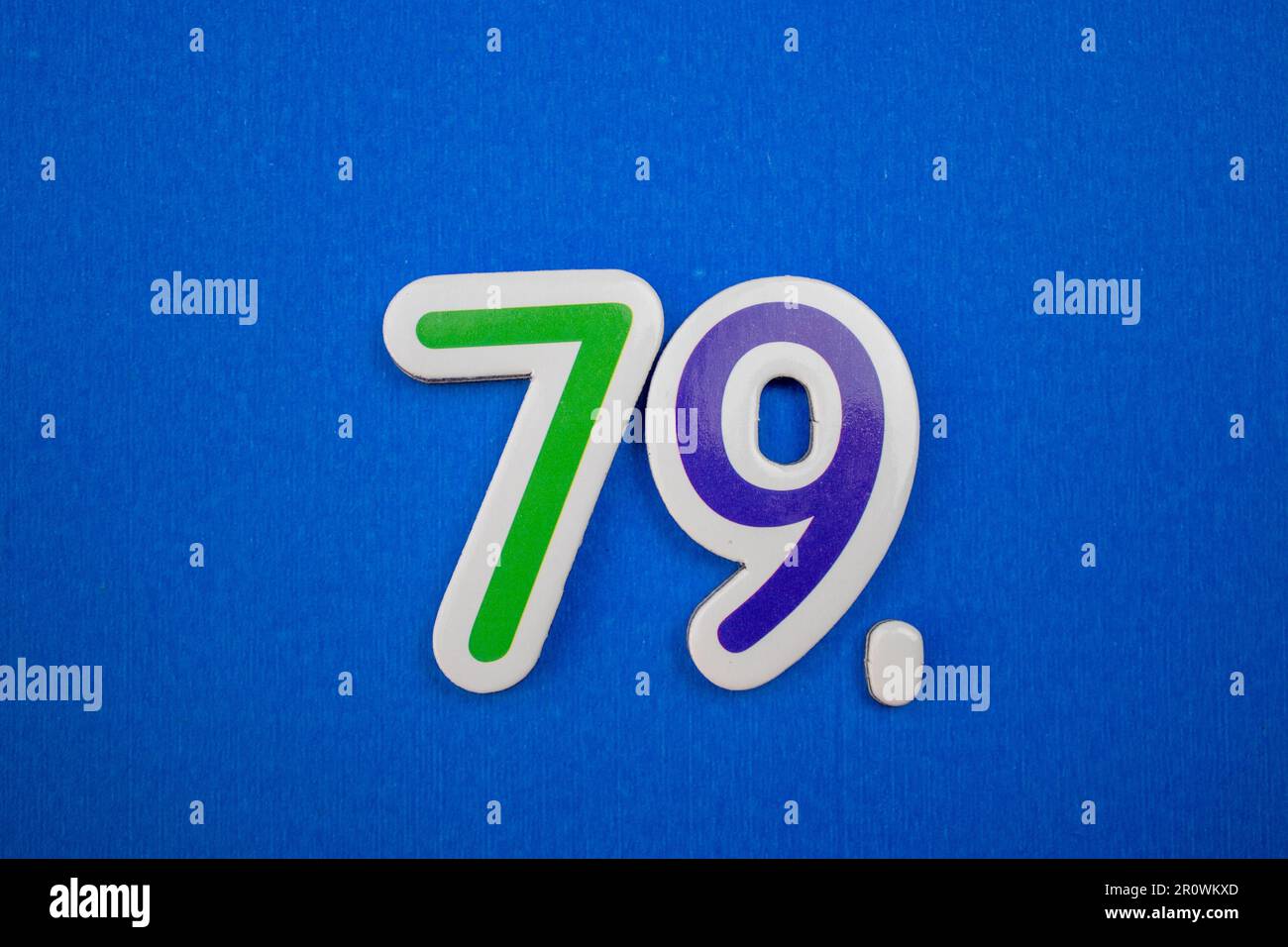 The number 79, placed on a blue background, photographed from above ...
