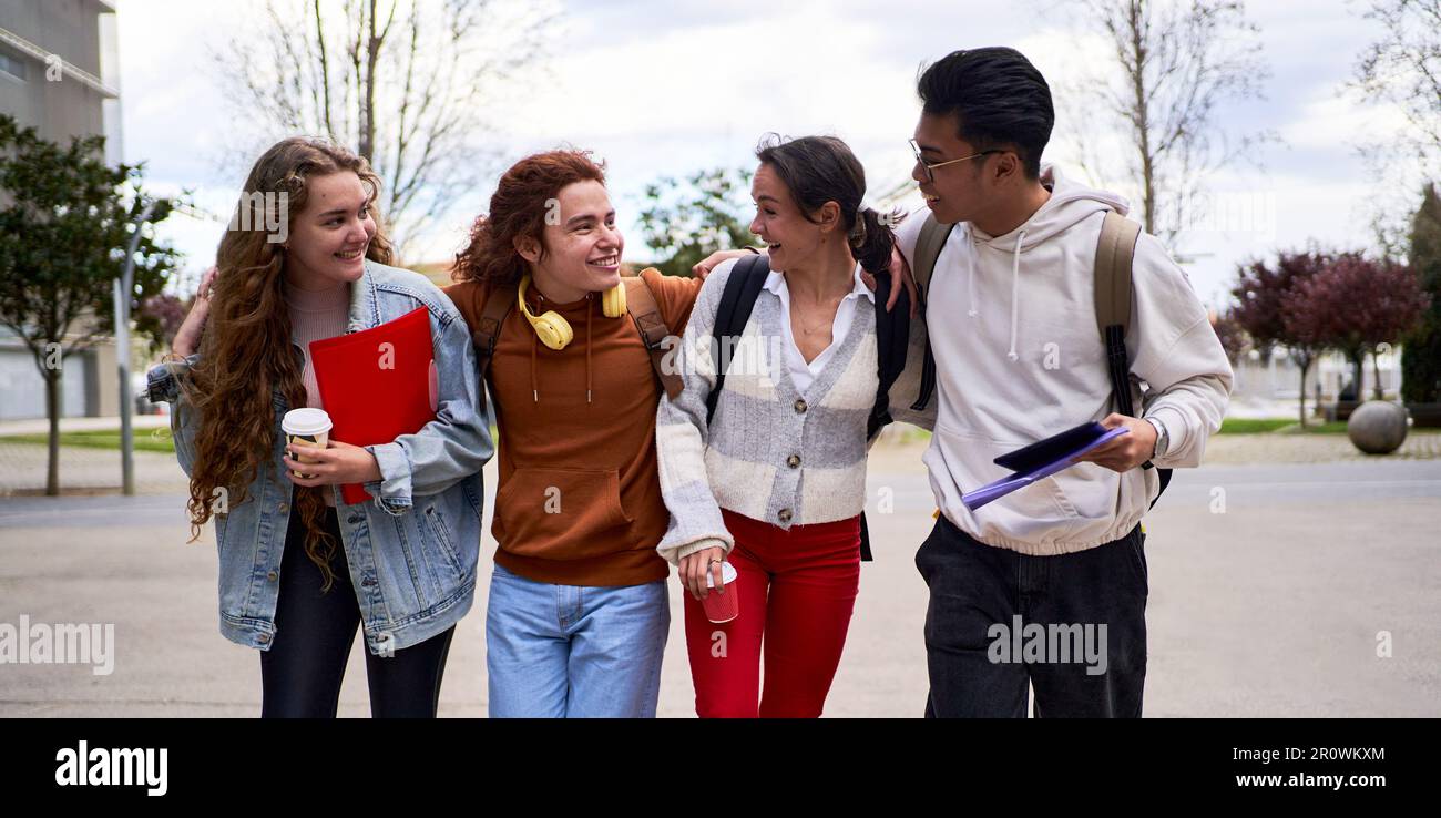 Diverse group of students walking outside the university, talking and ...