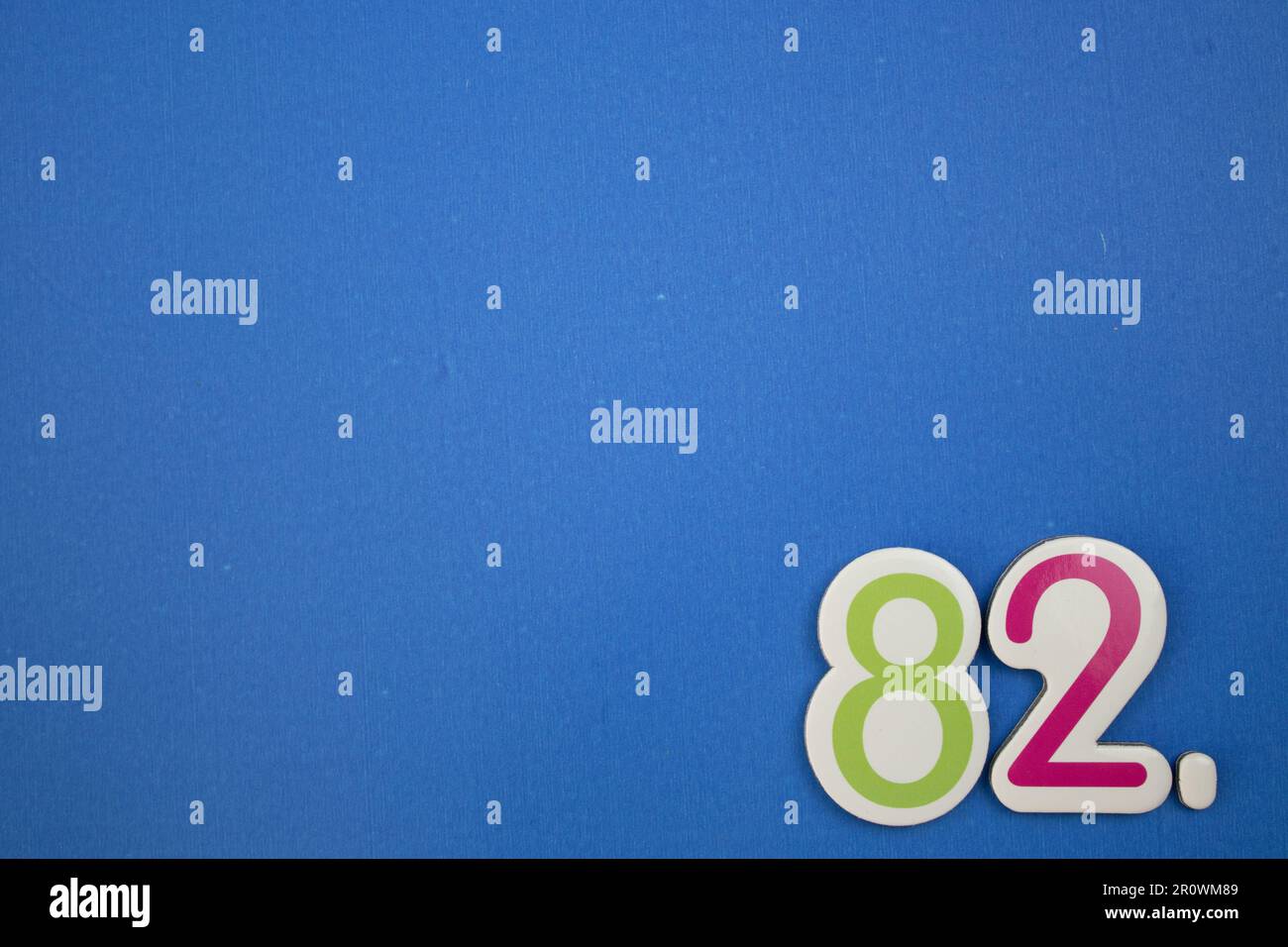 The number 82, placed on the edge of a blue background, photographed ...