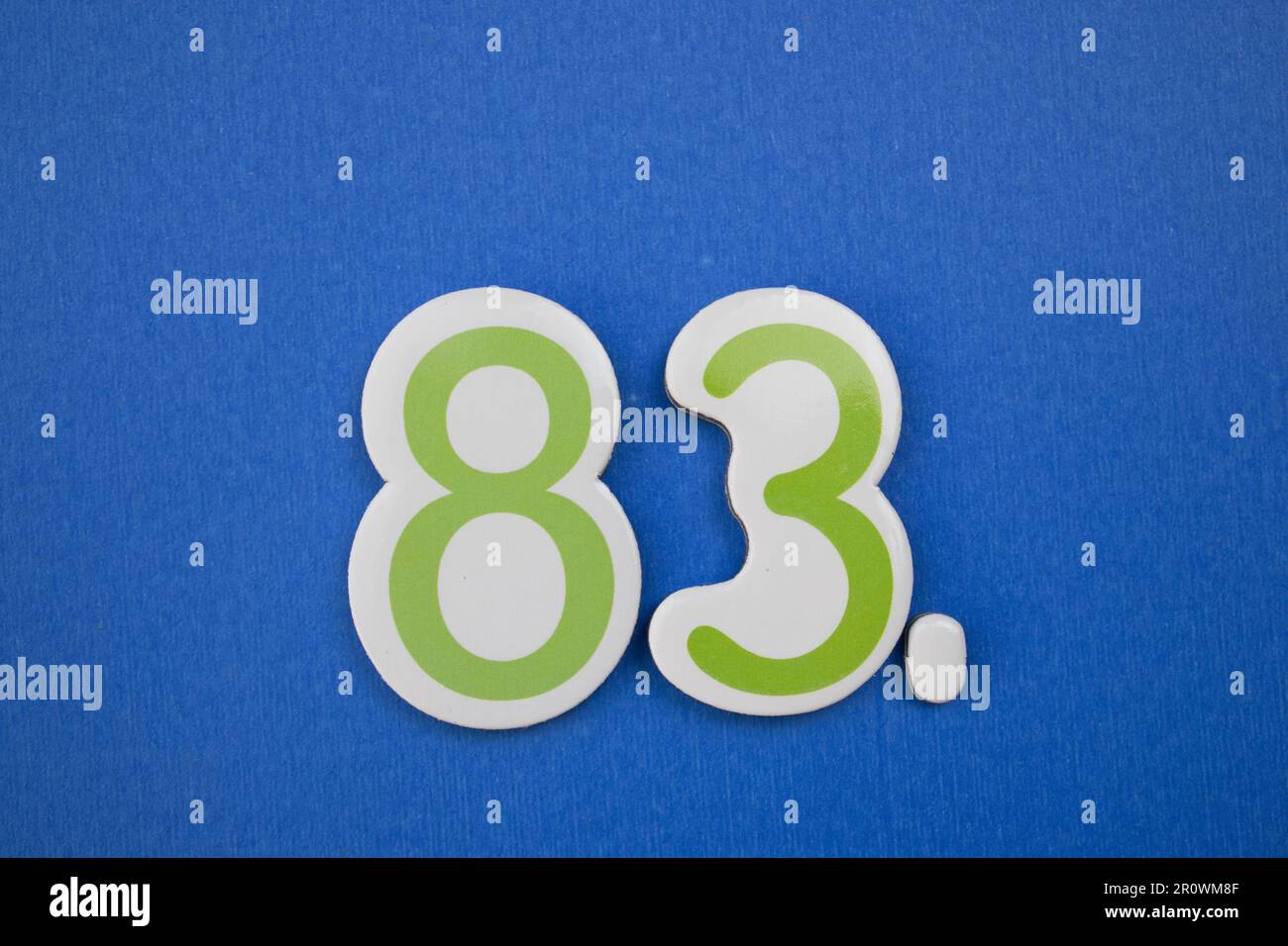The number 83 in green color, photographed from above, placed on a blue background Stock Photo ...