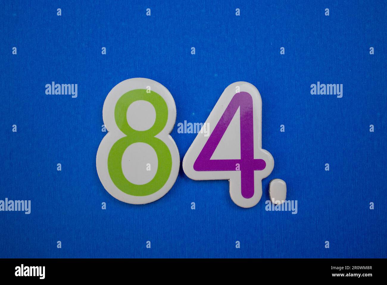 The number 84, placed on a blue background, photographed from above ...