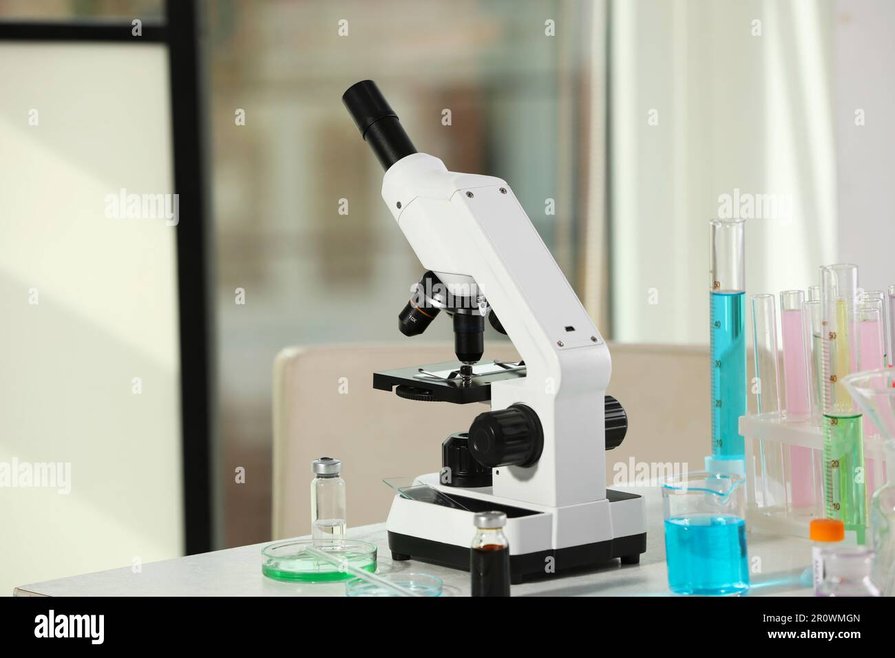 Modern microscope with glass slide on white table in laboratory, space ...