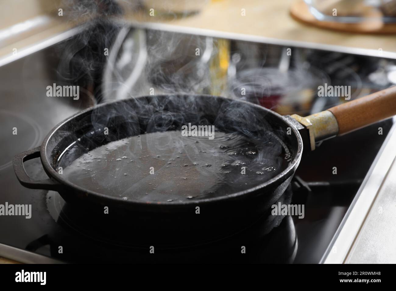 Frying pan with hot used cooking oil on stove Stock Photo - Alamy
