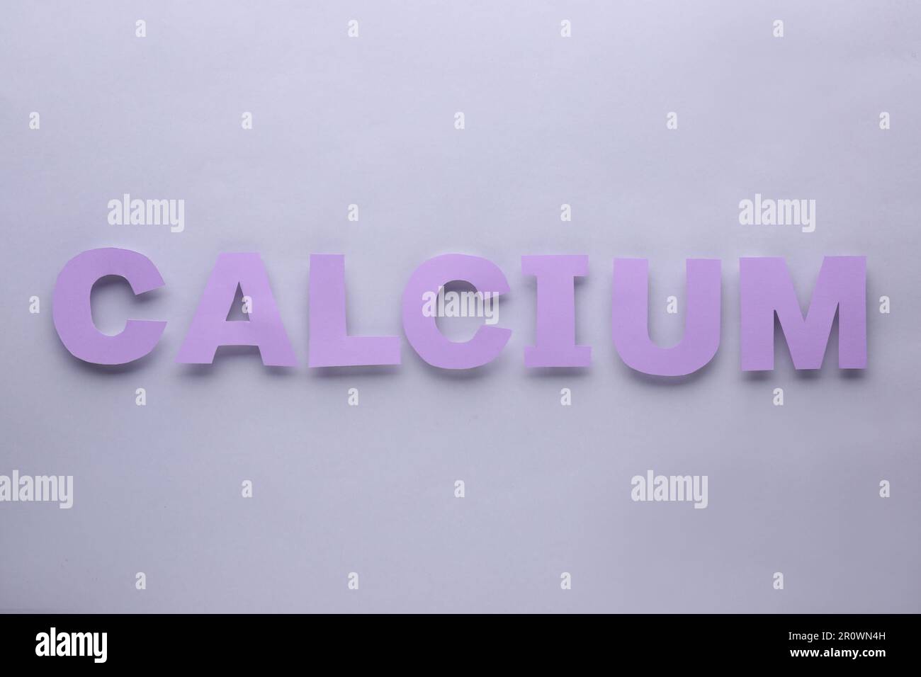 Word Calcium made of purple letters on light grey background, flat lay ...
