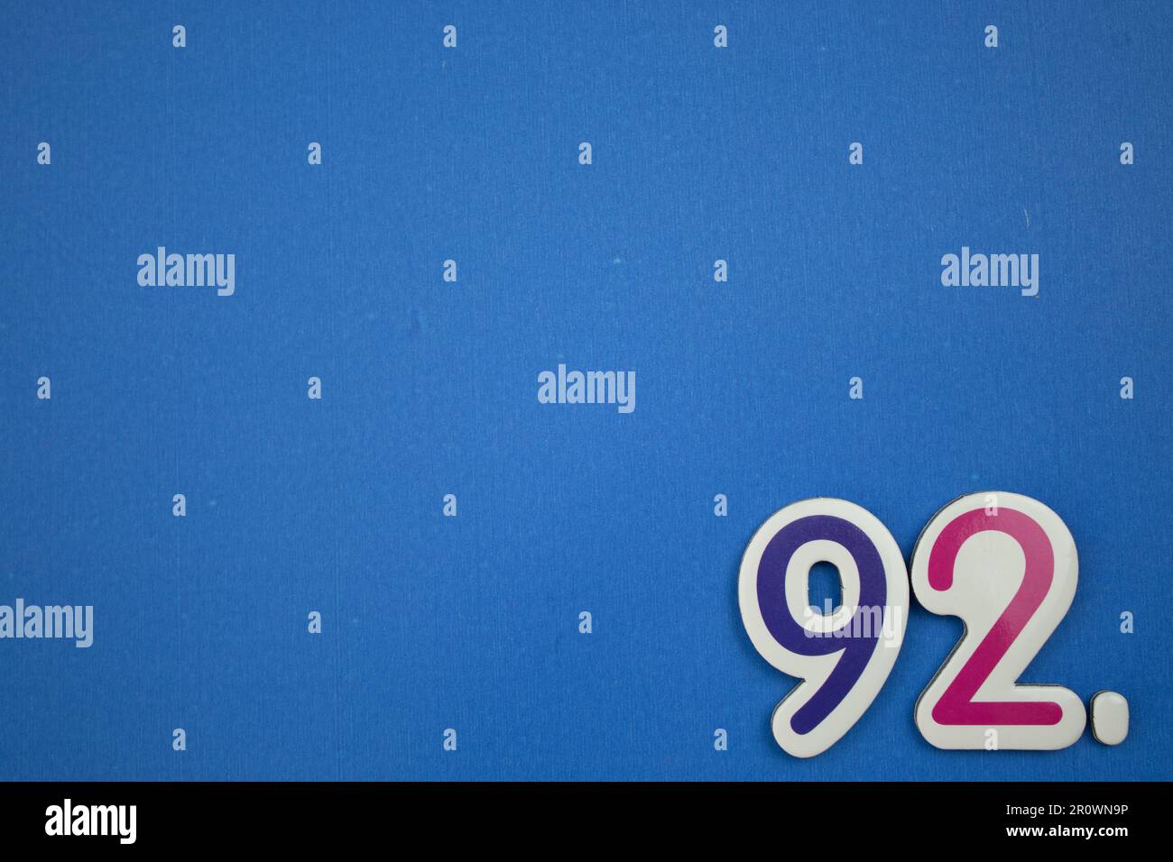The number 92, placed on the edge of a blue background, photographed ...