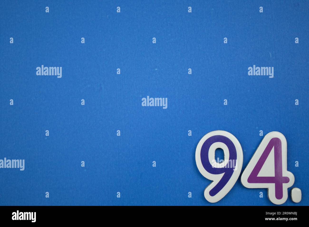 The number 94, placed on the edge of a blue background, photographed ...