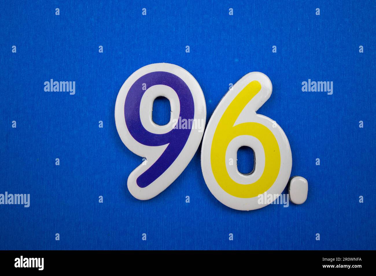 The number 96, placed on a blue background, photographed from above, colored blue and yellow ...