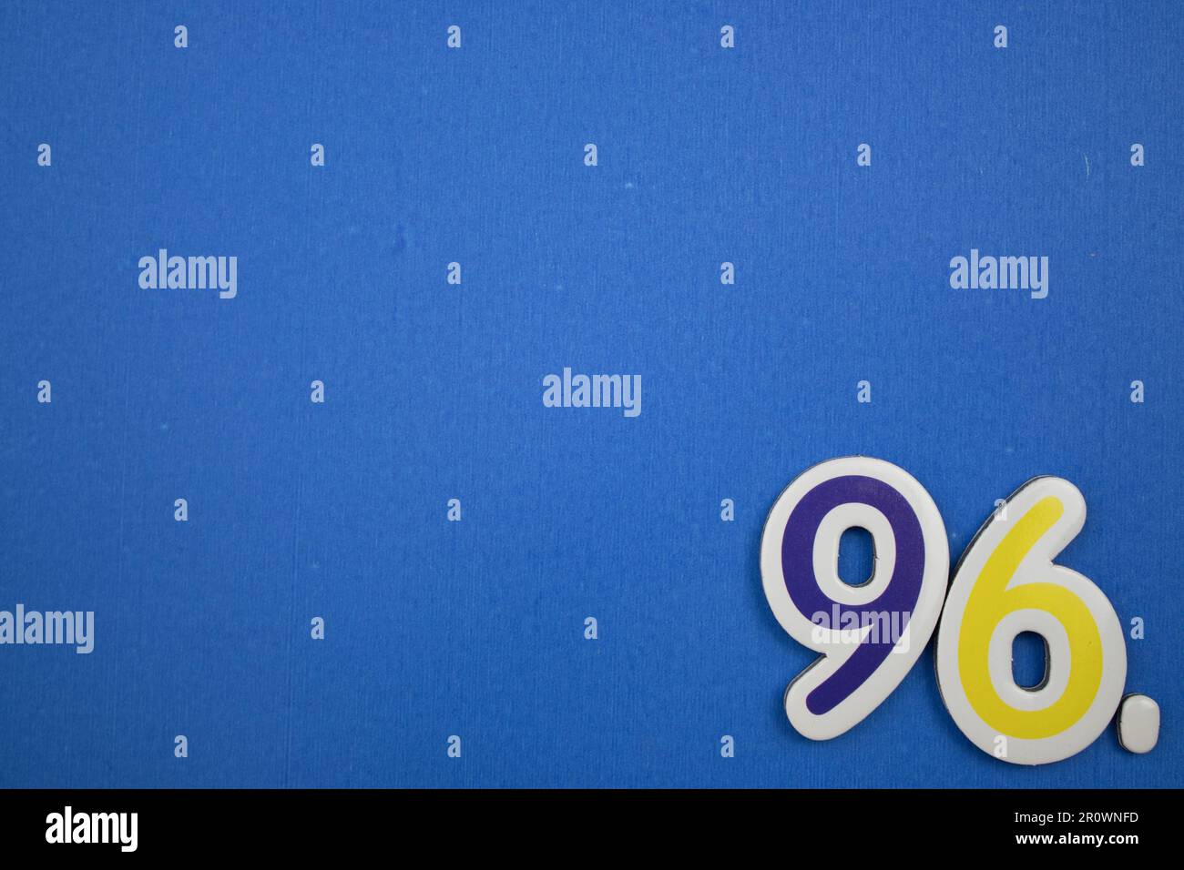 The number 96, placed on the edge of a blue background, photographed ...