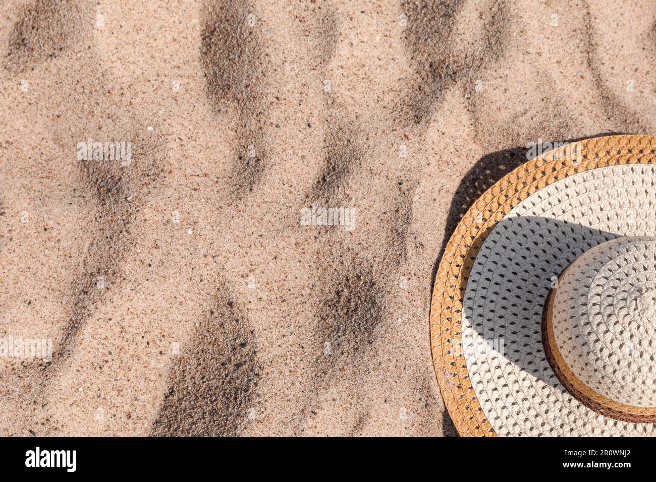 Beautiful beige straw hat on sand, top view. Space for text Stock Photo ...