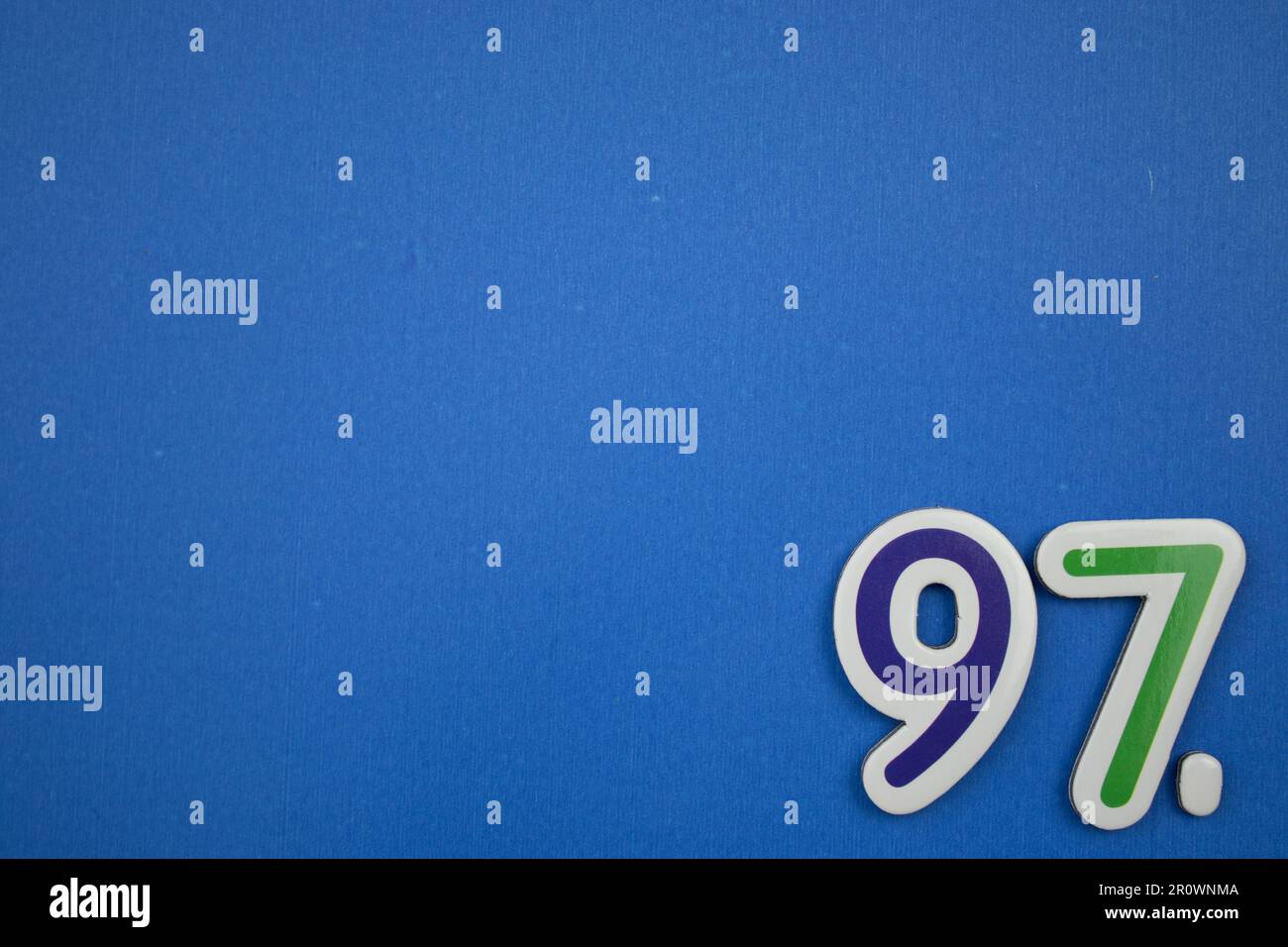 The number 97, placed on the edge of a blue background, photographed ...