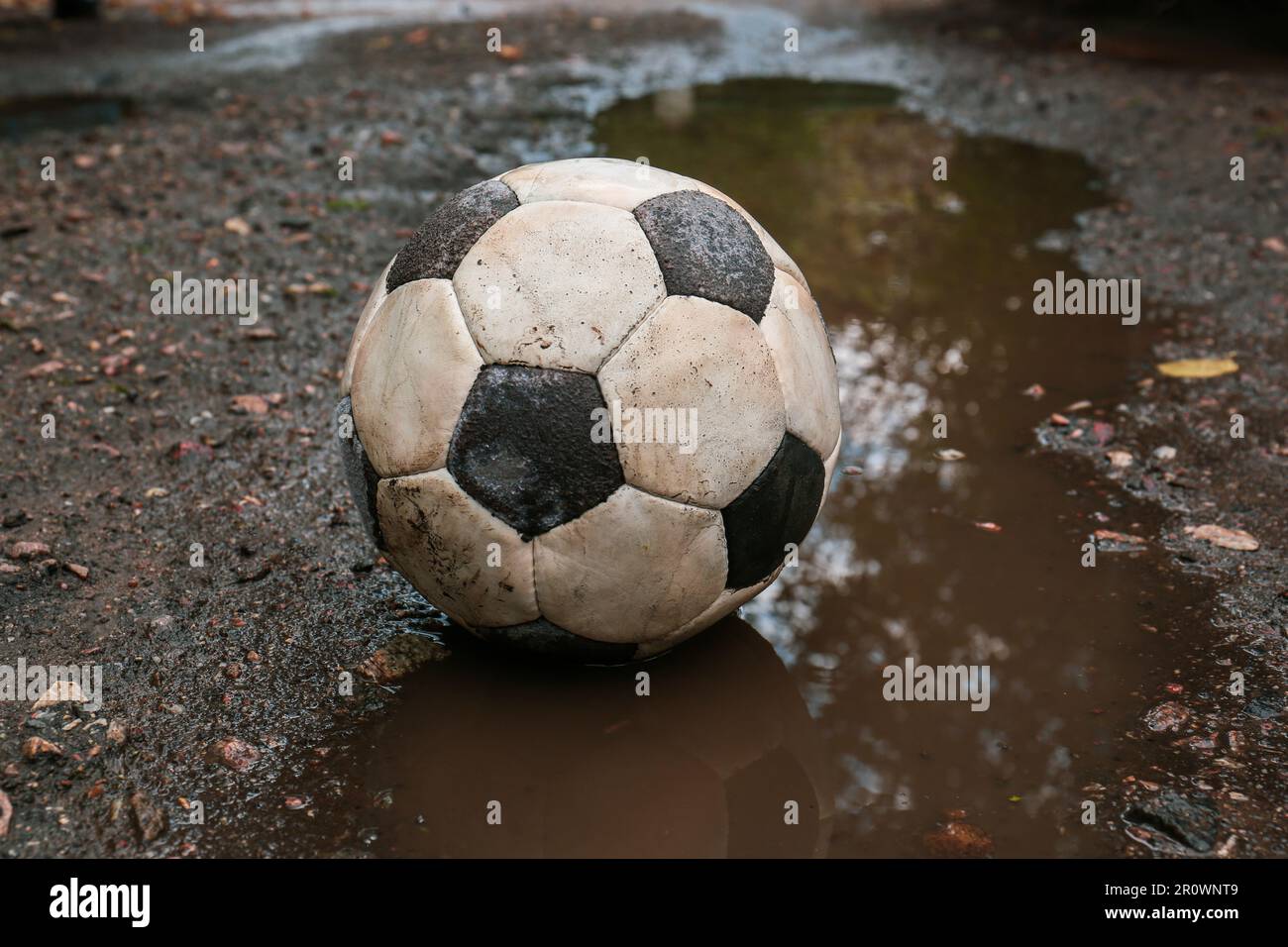 Dirty soccer ball in muddy puddle outdoors Stock Photo - Alamy