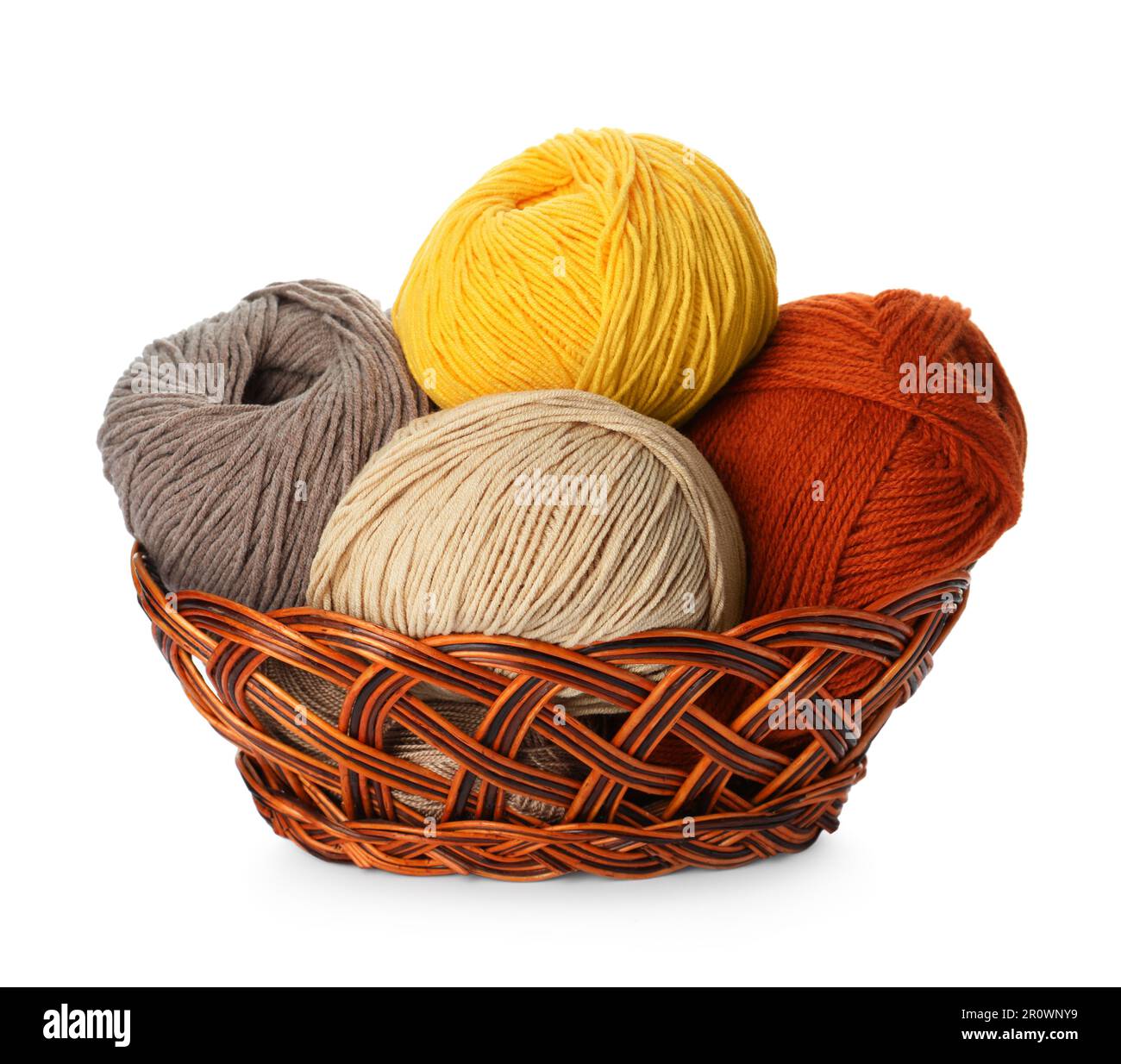 Different balls of woolen knitting yarns in wicker basket on white ...