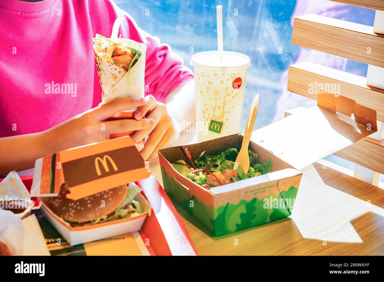 WARSAW, POLAND - SEPTEMBER 16, 2022: Woman eating roll with chicken in ...