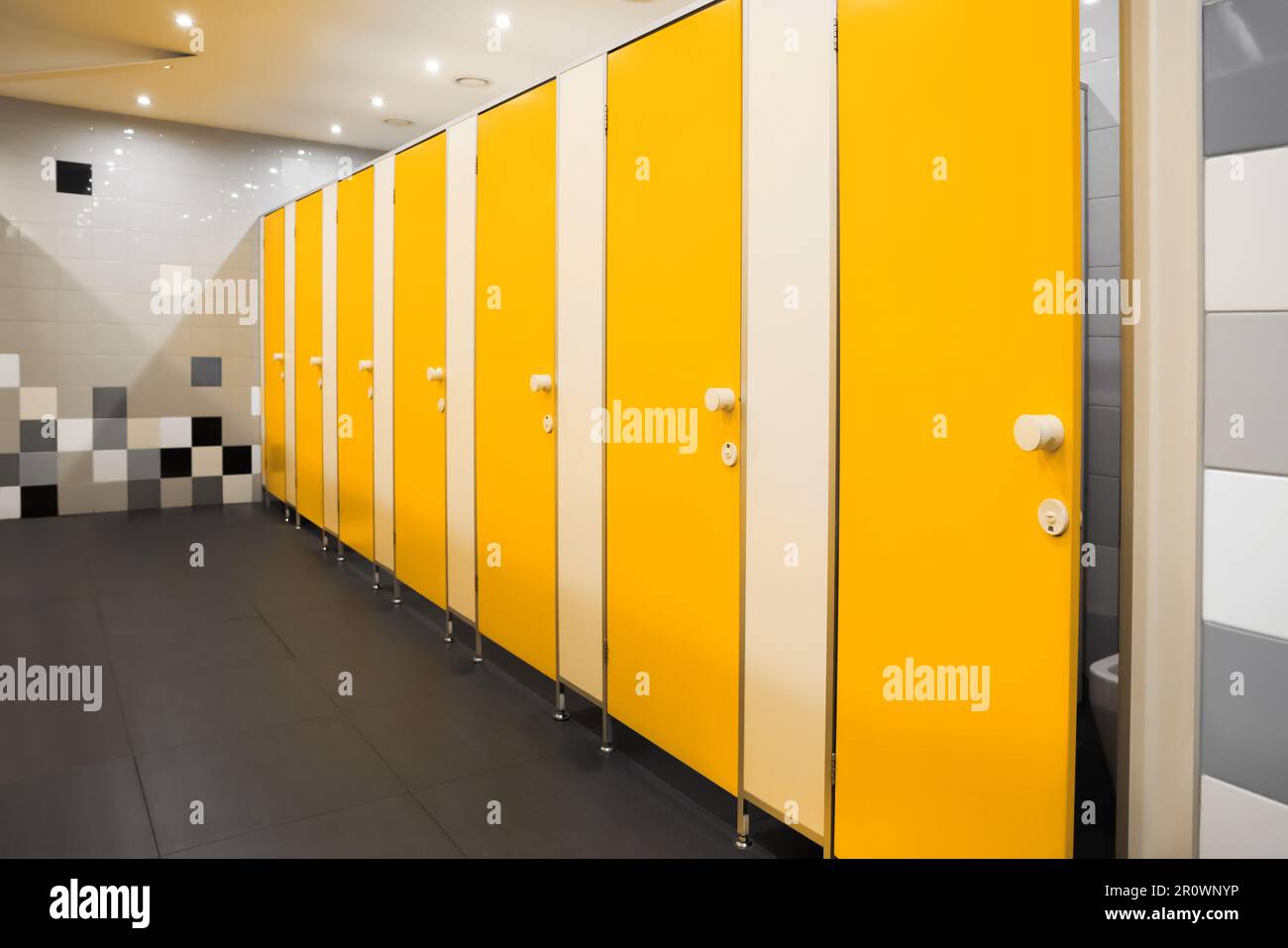 Public toilet interior with bright yellow stalls Stock Photo - Alamy