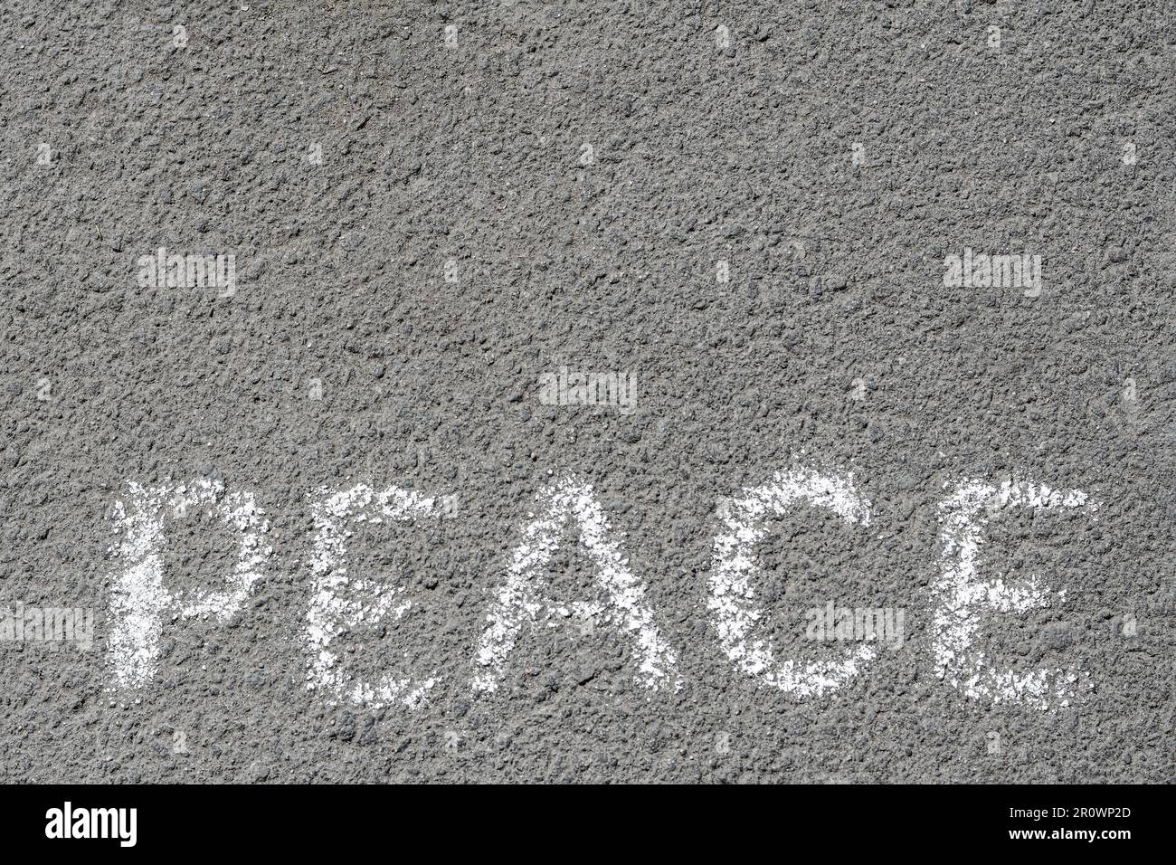 Word Peace written with white chalk on asphalt outdoors, top view ...