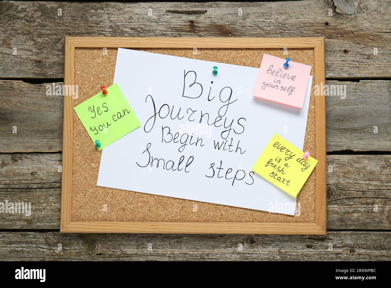 Corkboard with motivational quotes on wooden table, top view Stock ...