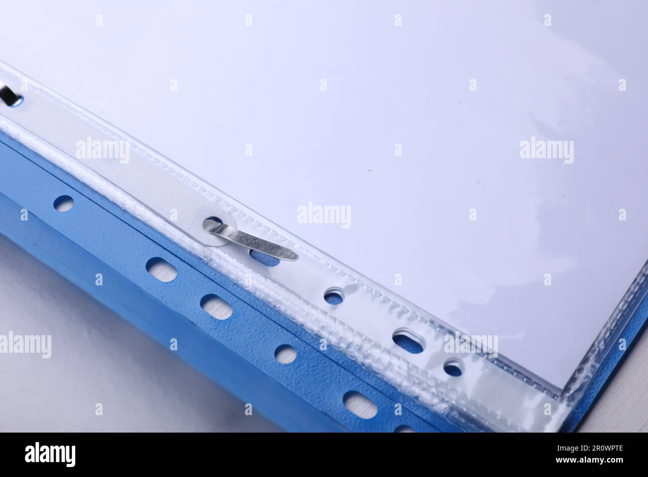 File folder with punched pockets and paper sheets on white background ...